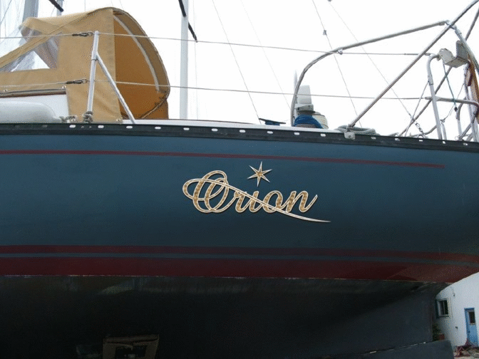 Orion boat letters on a dark blue hull - Boat Lettering